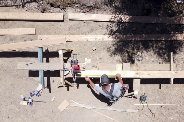 Overhead view of a carpenter working outside using a circular saw to ...